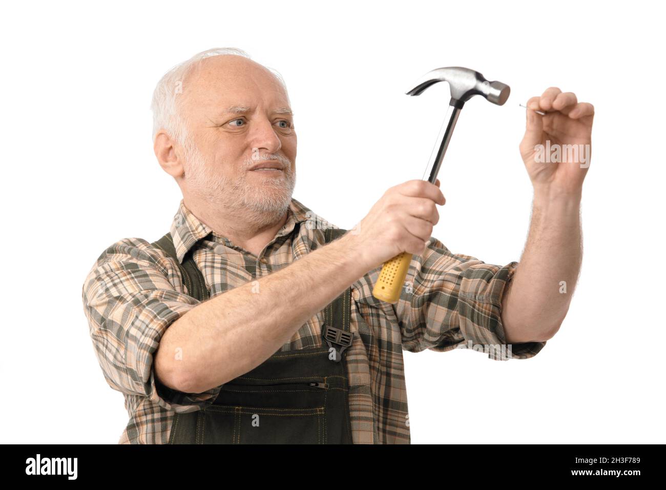 Senior man hammering Stock Photo - Alamy