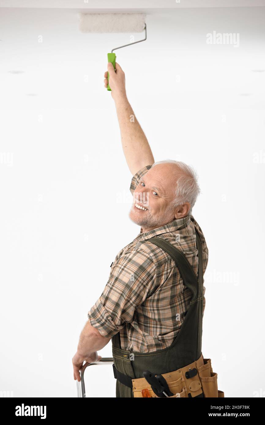 Elderly man painting the ceiling Stock Photo - Alamy