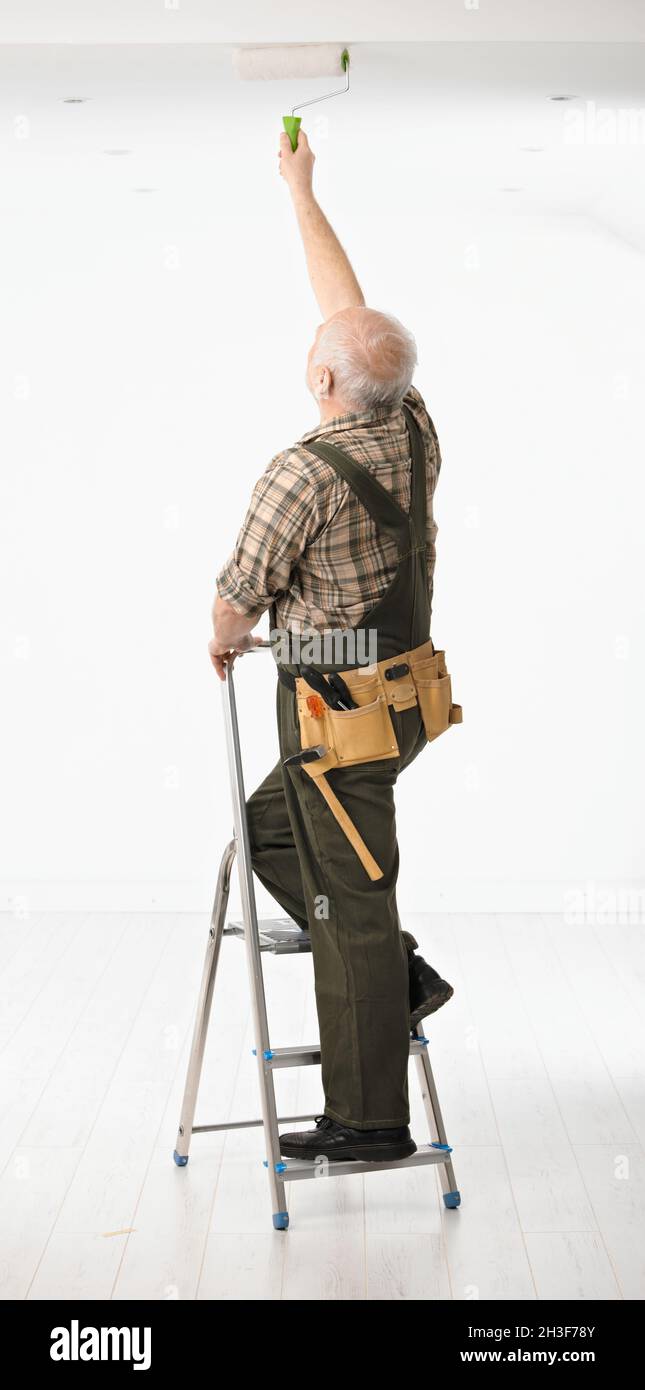 Senior handyman painting the ceiling Stock Photo - Alamy