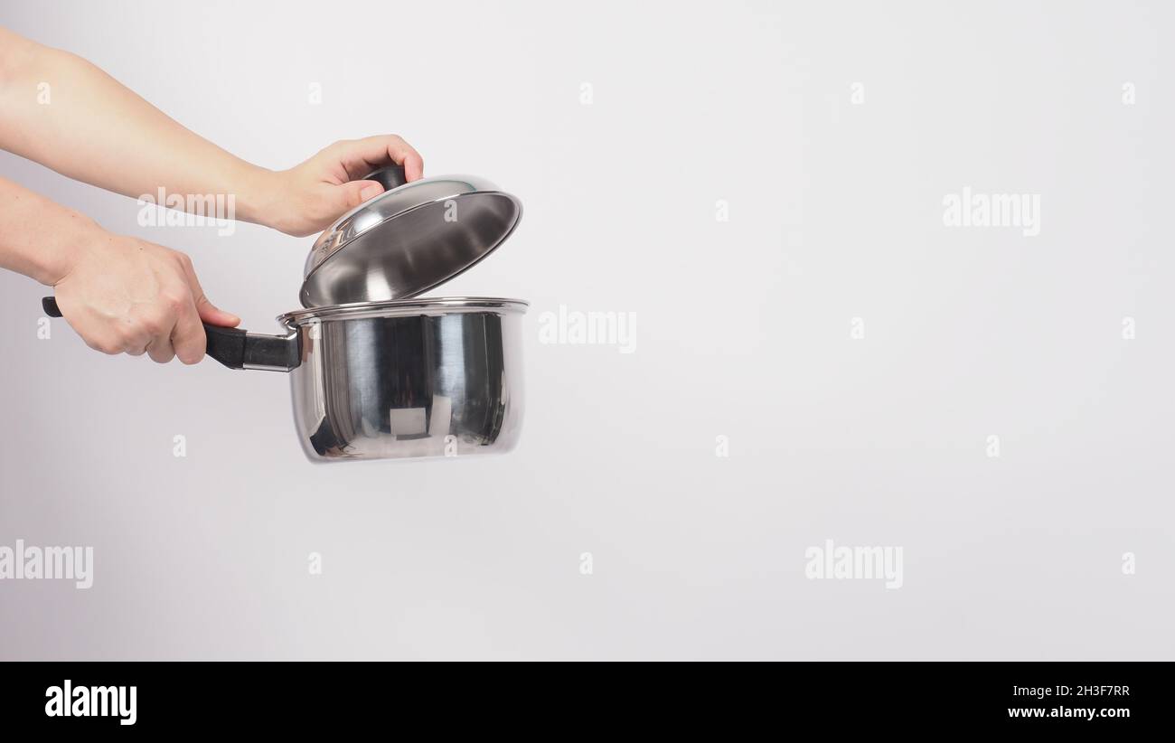 Pot cleaning. Man hand on white background cleaning the non stick pot ...