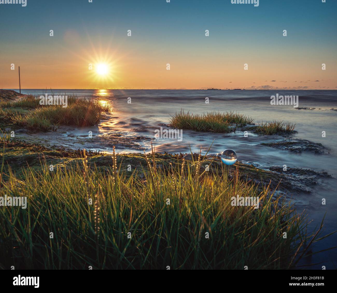 Beautiful sunset at north sea beach with a lensball Stock Photo - Alamy