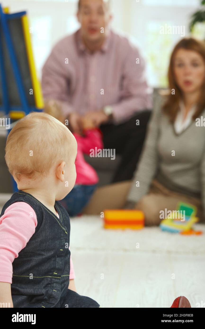 Baby looking back at parents Stock Photo - Alamy