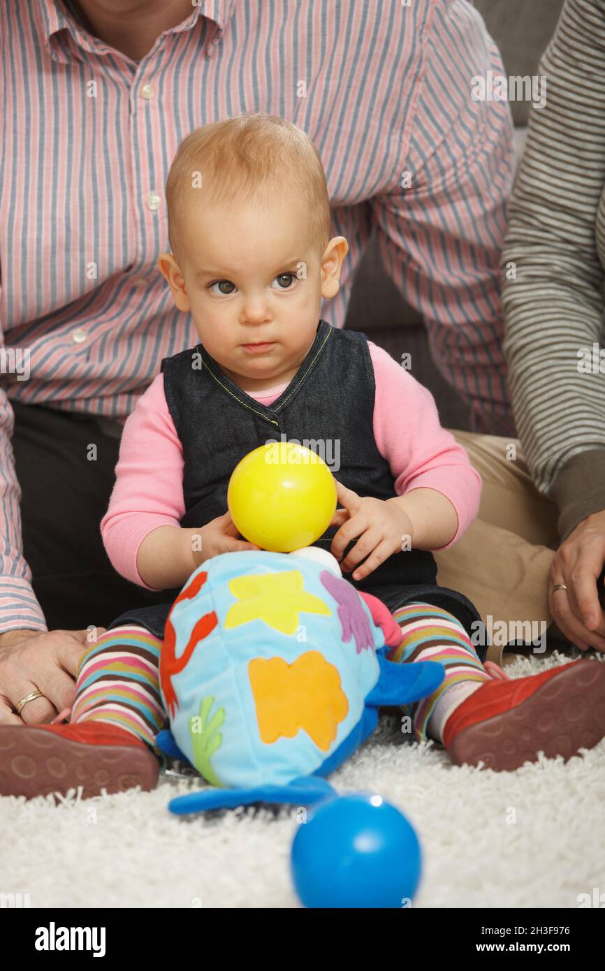 Baby girl holding ball Stock Photo - Alamy