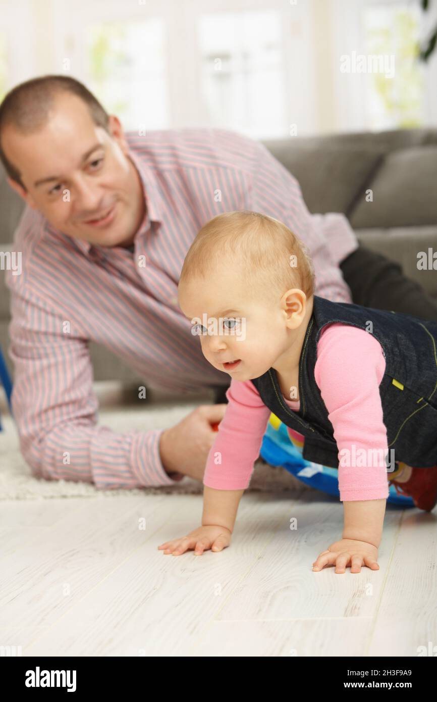 Baby crawling on floor Stock Photo - Alamy