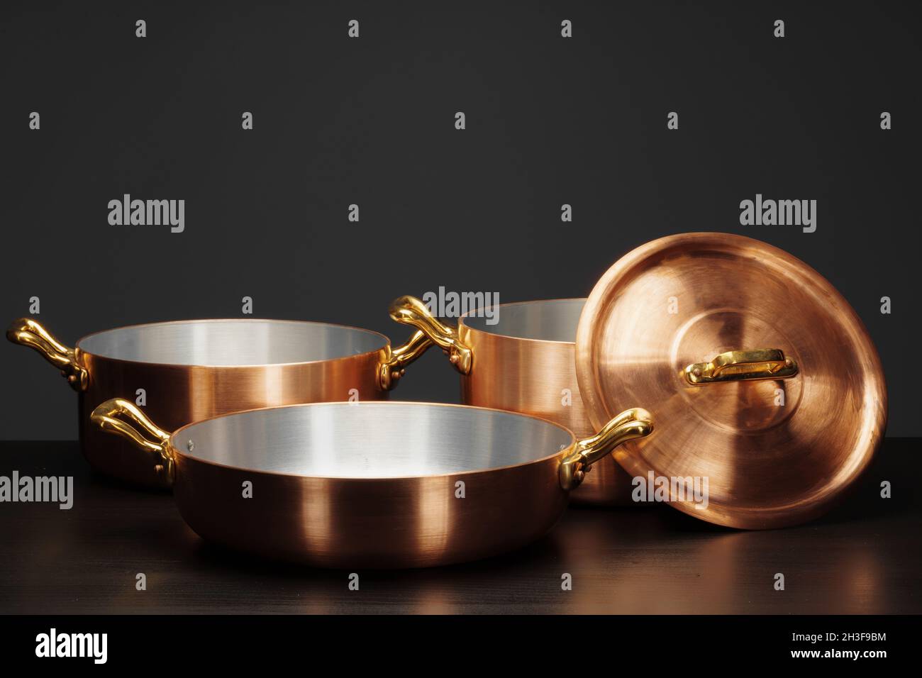 Shiny vintage copper cookware over dark background Stock Photo - Alamy