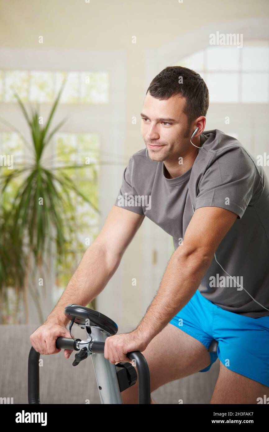 Man training on exercise bike Stock Photo - Alamy