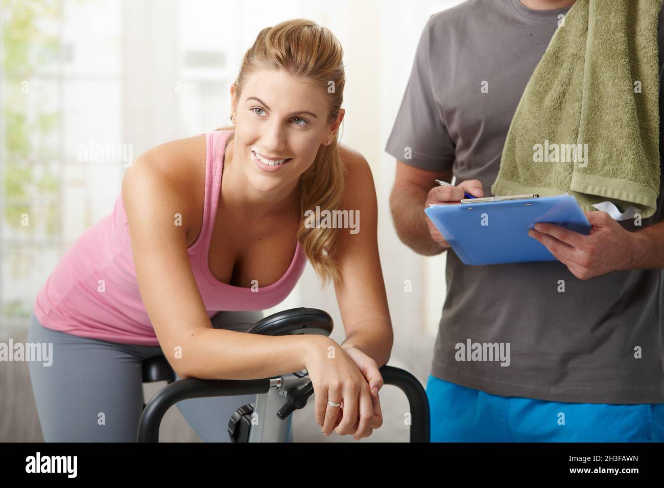 Woman training on exercise bike Stock Photo - Alamy