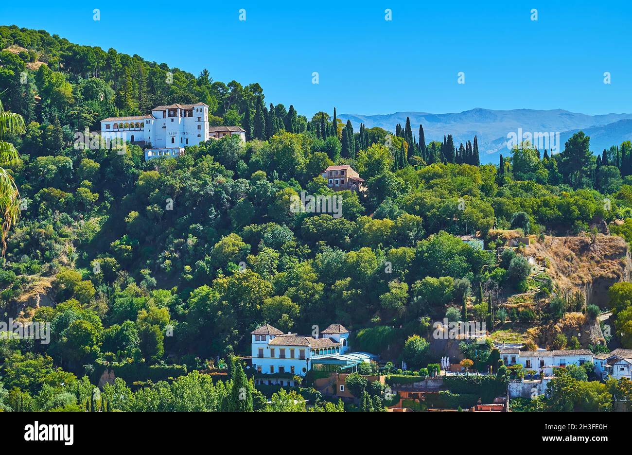 The medieval white Palace of Generalife surrounded with lush greenery ...