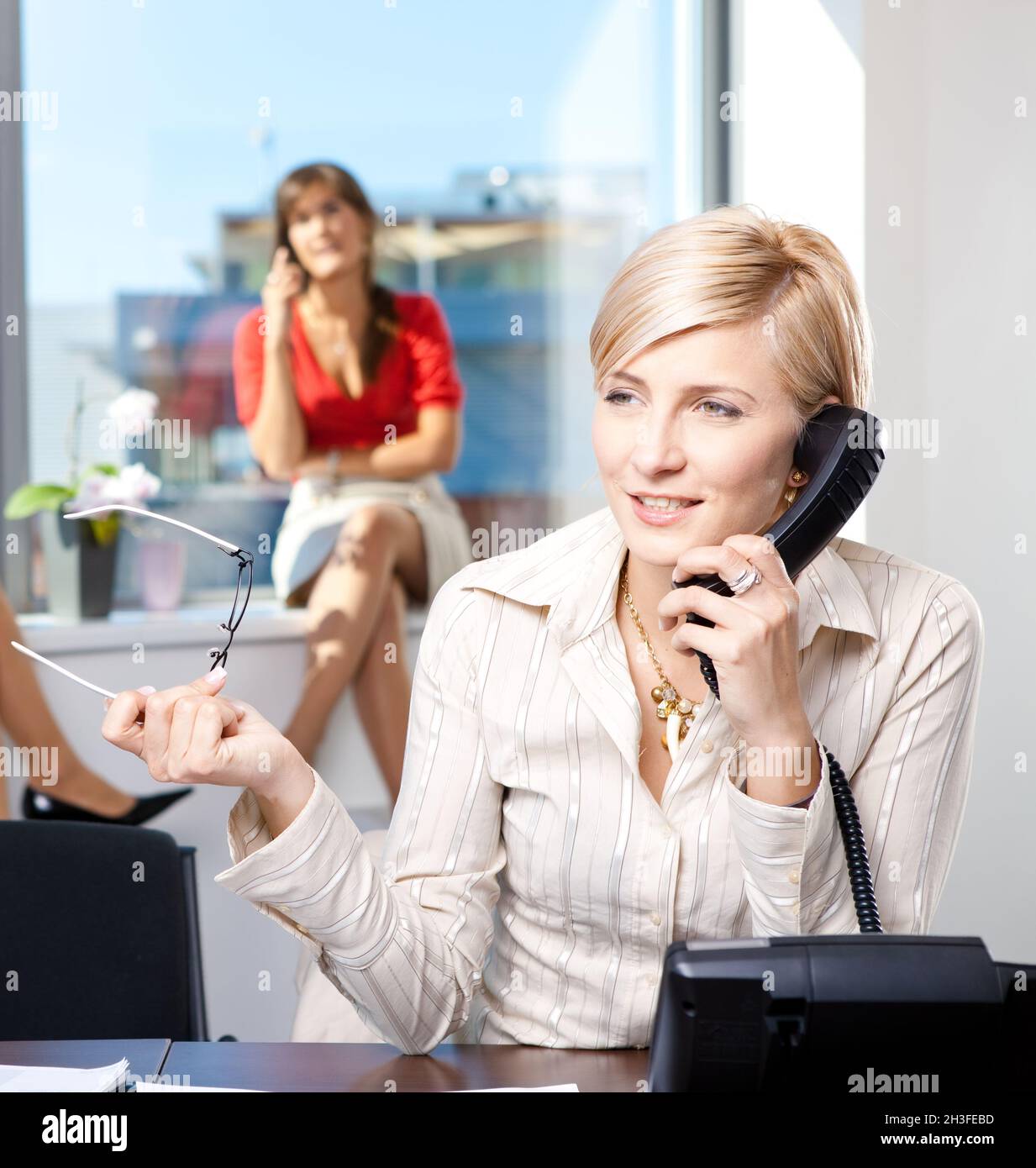 Businesswoman talking on landline phone Stock Photo - Alamy
