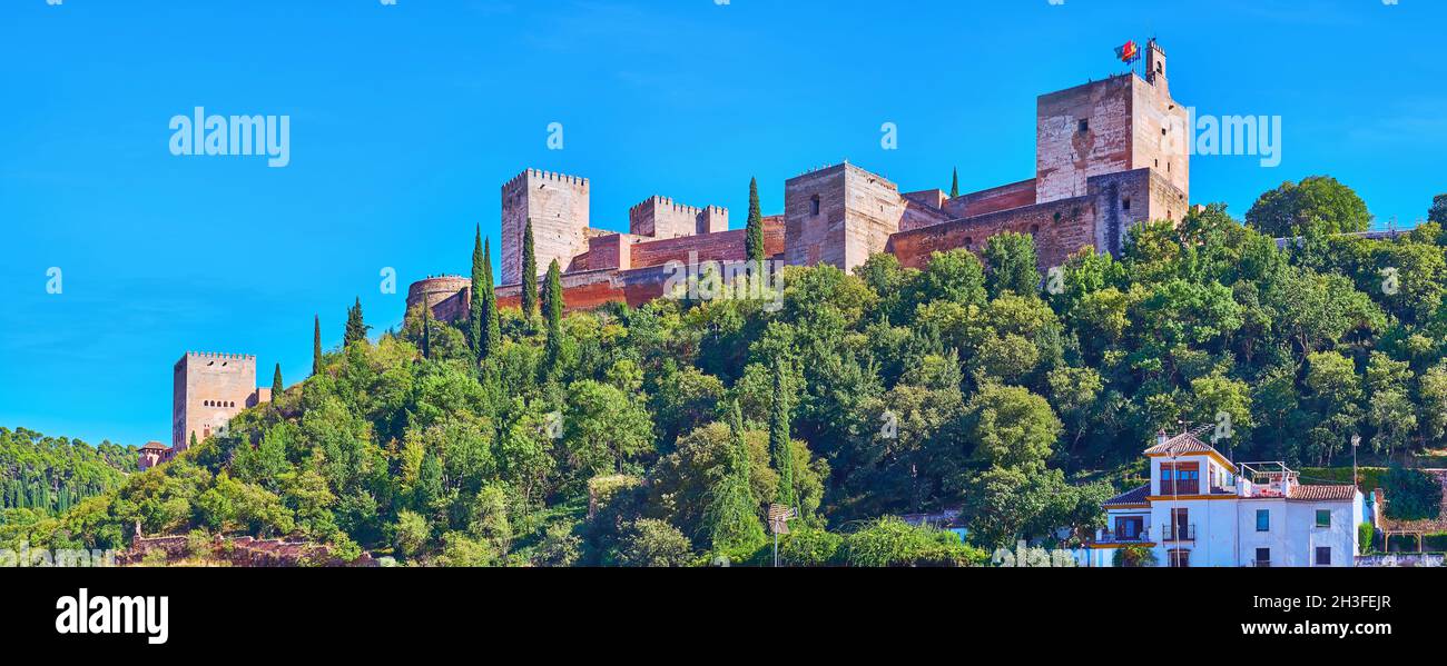 Panorama of Alhambra Fortress with tall brick and stone towers amid the ...