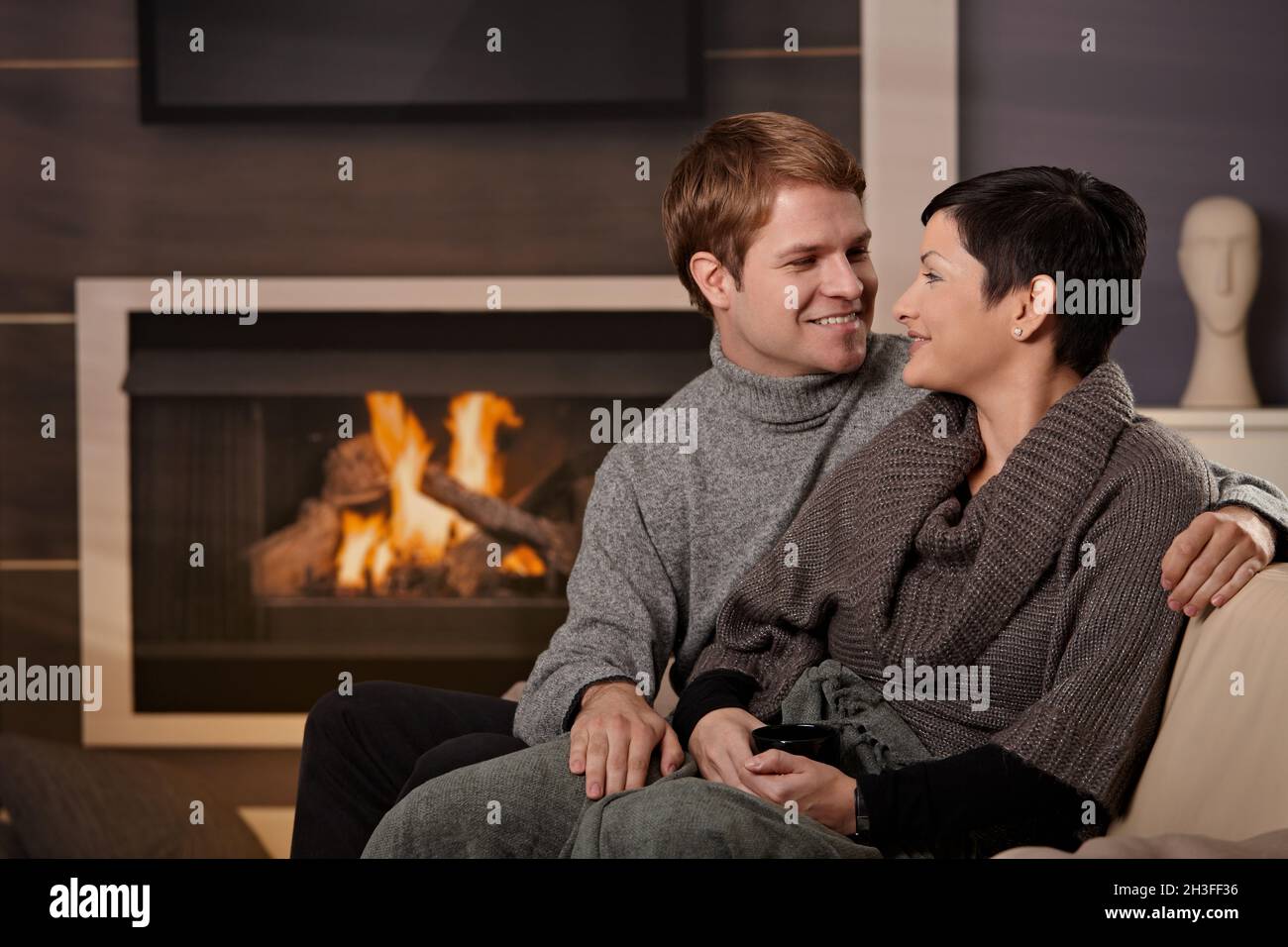 Couple hugging home Stock Photo - Alamy