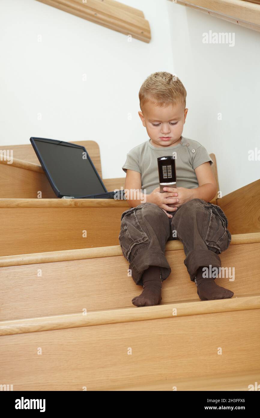 Little boy sitting on stairs Stock Photo - Alamy