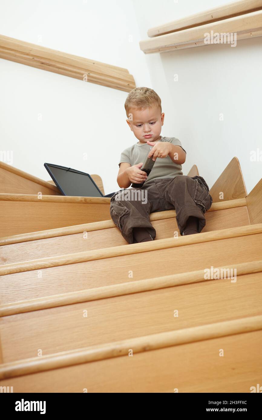 Little boy sitting on stairs Stock Photo - Alamy