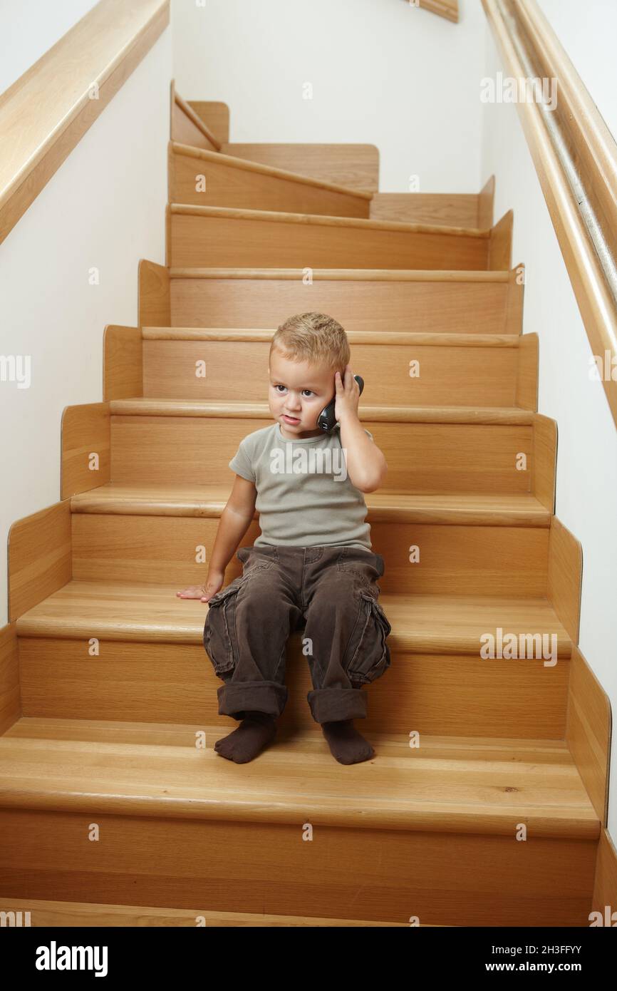 Little boy sitting on stairs Stock Photo - Alamy