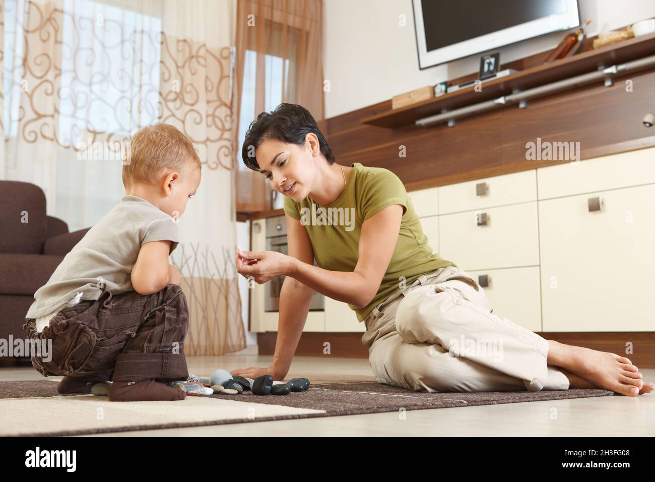 Little boy playing with pebbles Stock Photo - Alamy