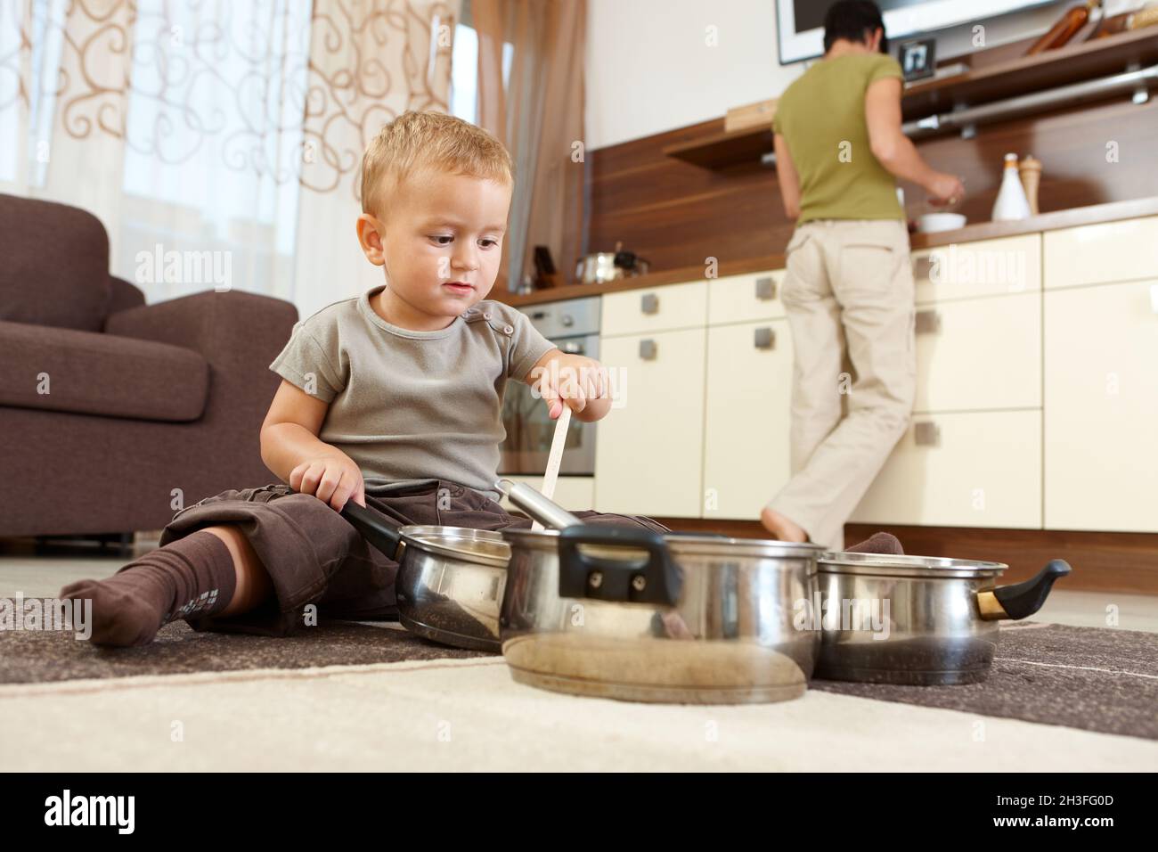 Little boy playing in kitchen Stock Photo - Alamy