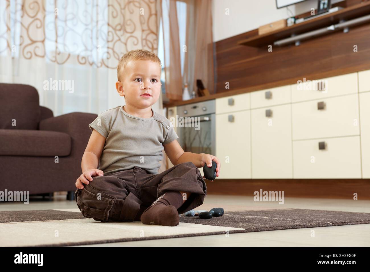 Little boy playing with pebbles Stock Photo - Alamy