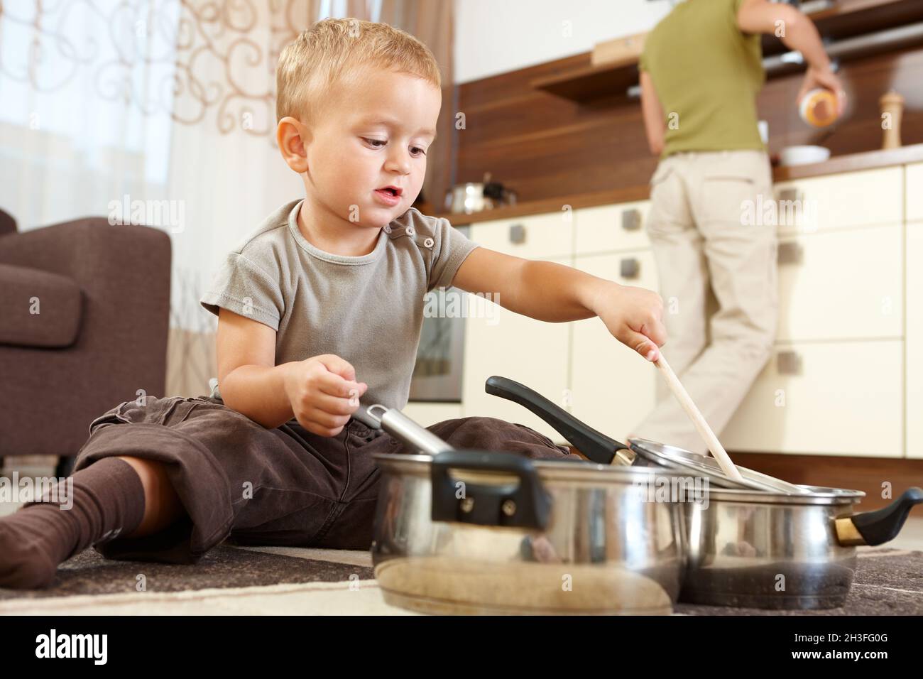Little boy playing in kitchen Stock Photo - Alamy