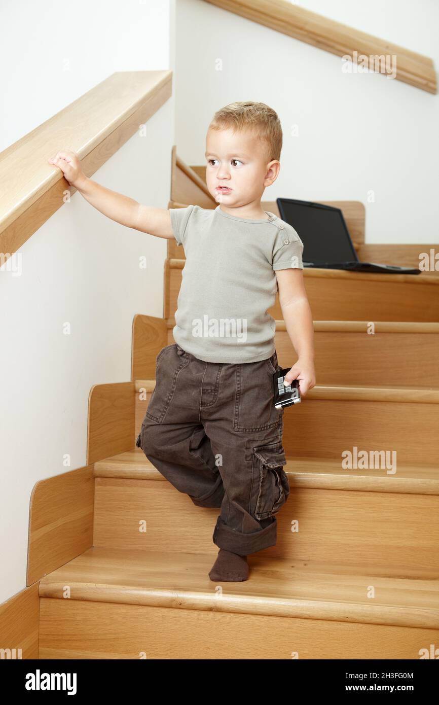 Little boy standing on stairs Stock Photo - Alamy