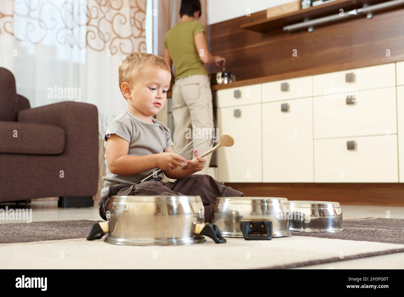 Little boy playing with cooking pots Stock Photo - Alamy
