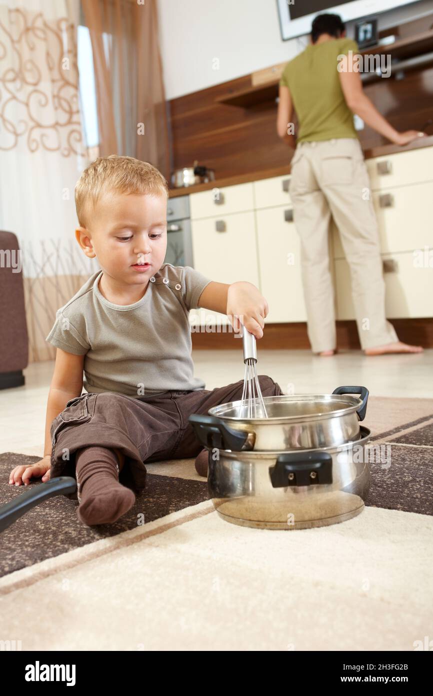Little boy playing in kitchen Stock Photo - Alamy