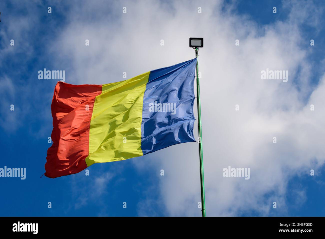 The Romanian national flags blowing in the wind in direct sunlight ...