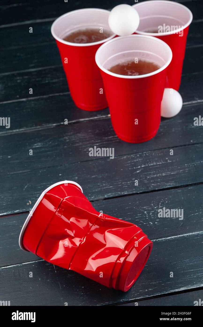 Wooden table with red cups and ball for beer pong Stock Photo - Alamy