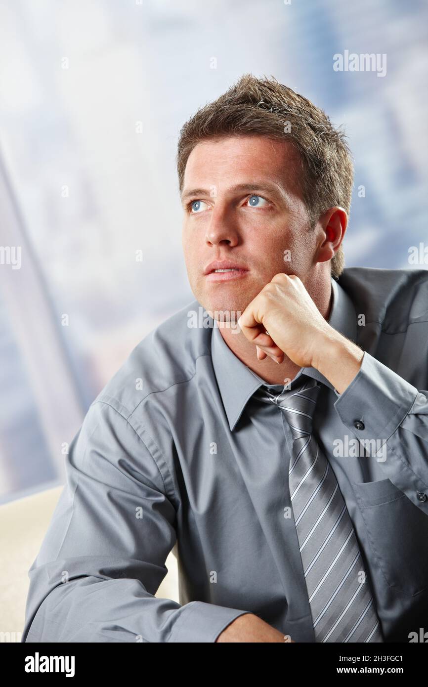 Portrait of businessman looking up thinking Stock Photo - Alamy