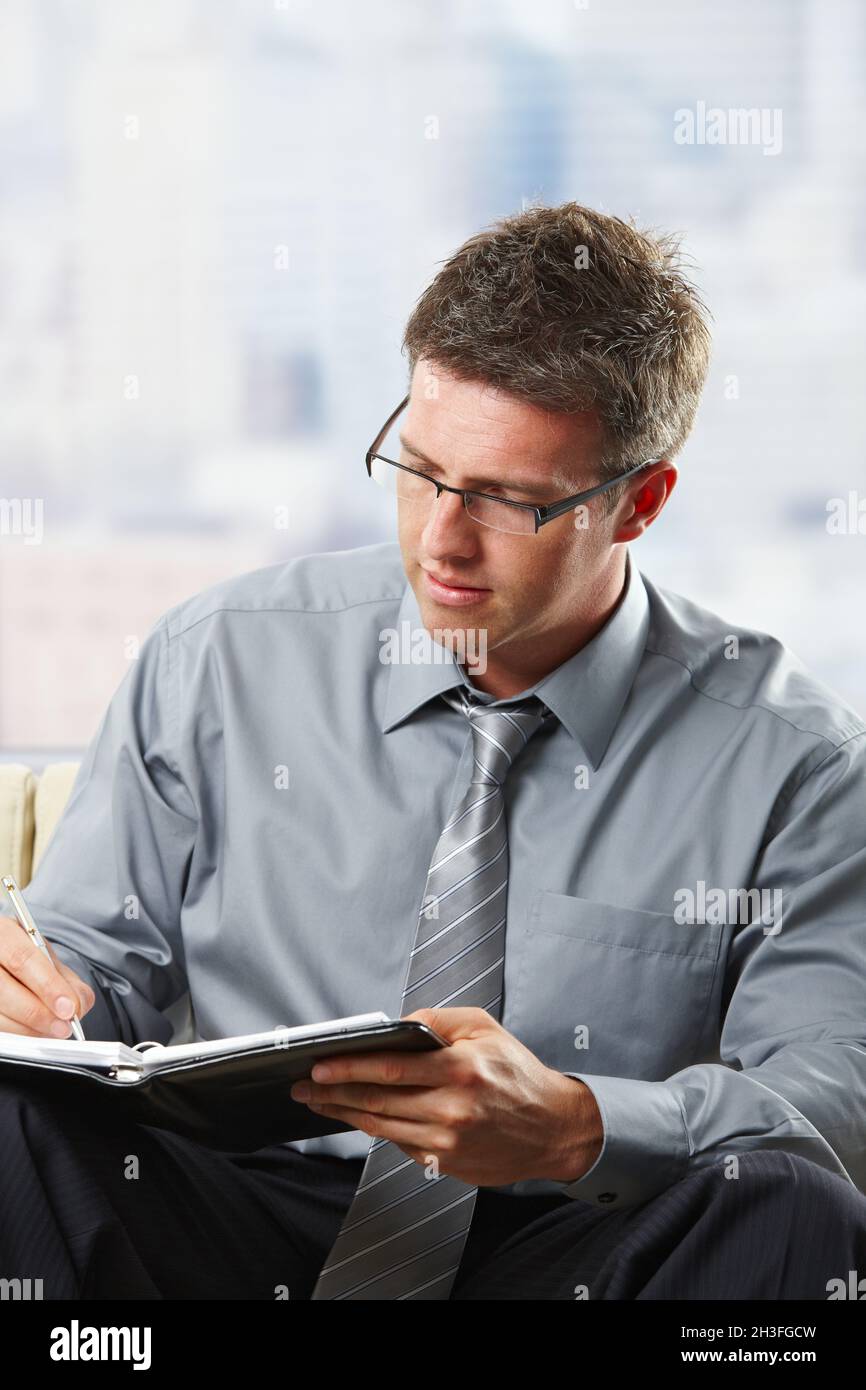 Professional taking notes into organiser Stock Photo - Alamy
