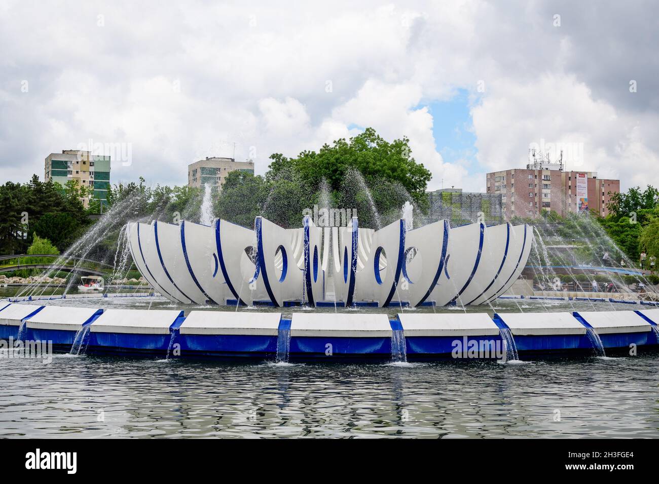 Landscape with the lake, decorative fountain and vivid green trees in ...