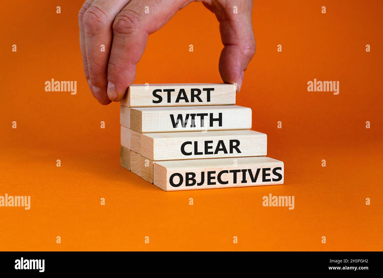 Start with clear objectives symbol. Wooden bloks with words 'Start with ...