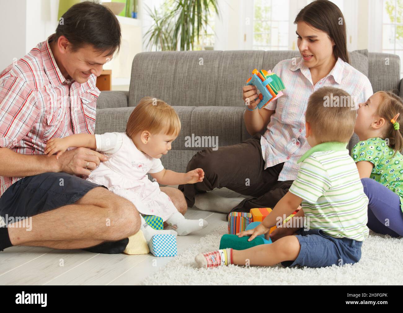 Happy nuclear family playing together at home Stock Photo - Alamy