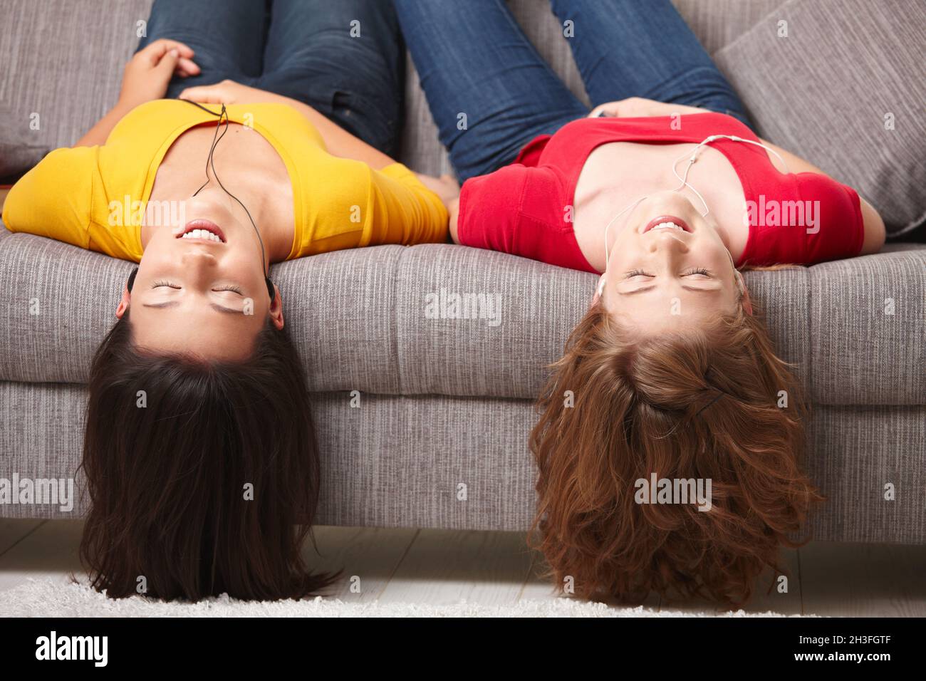 Teen girls resting on couch Stock Photo - Alamy