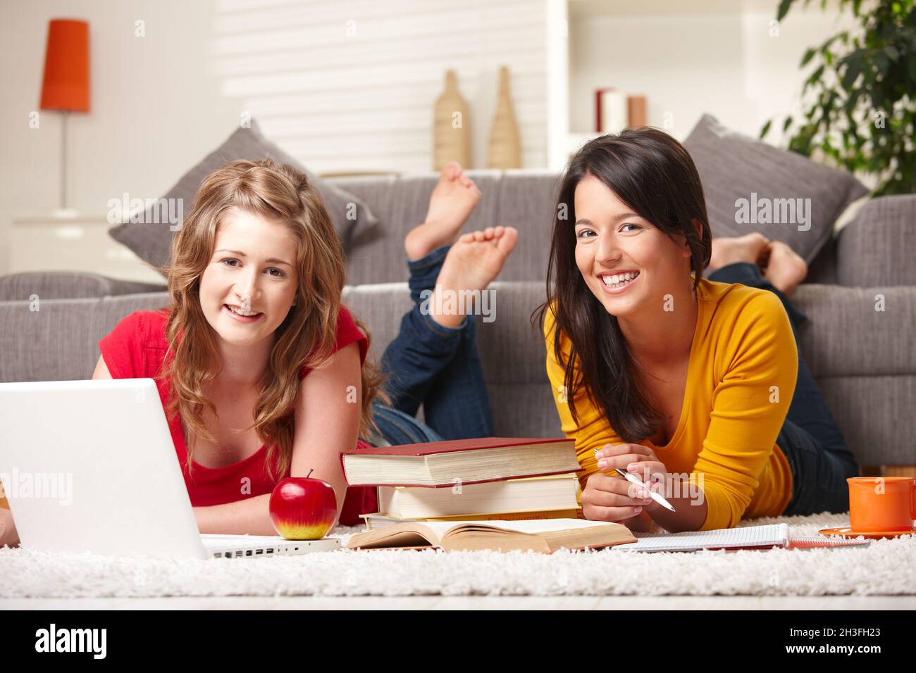 Happy girls with laptop and books Stock Photo - Alamy