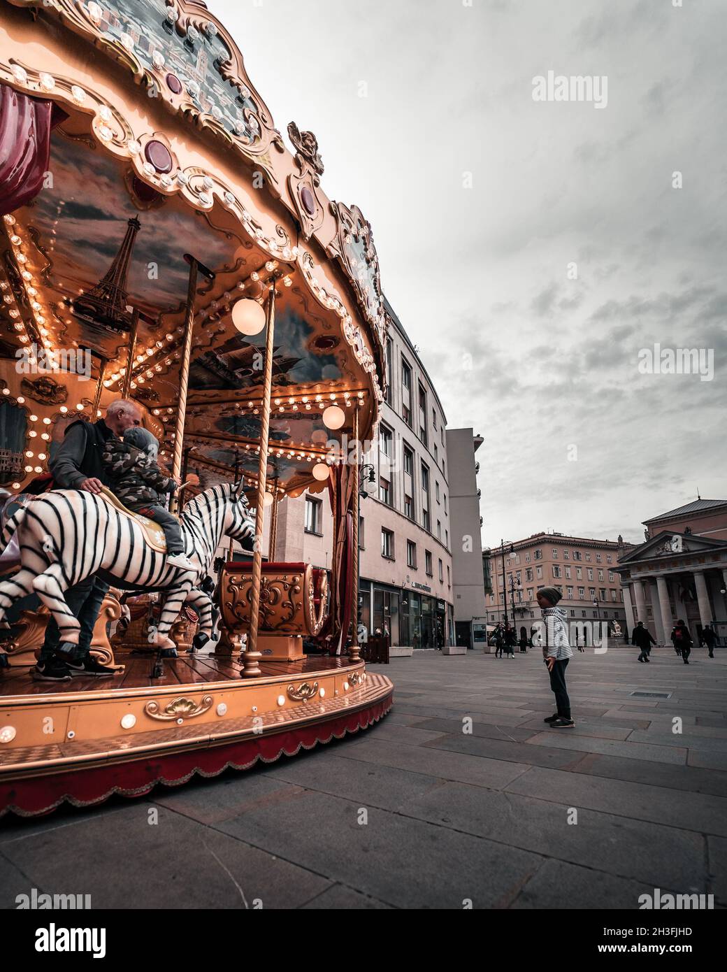 Kid standing in front of a carousel and wishing to get a ride Stock ...