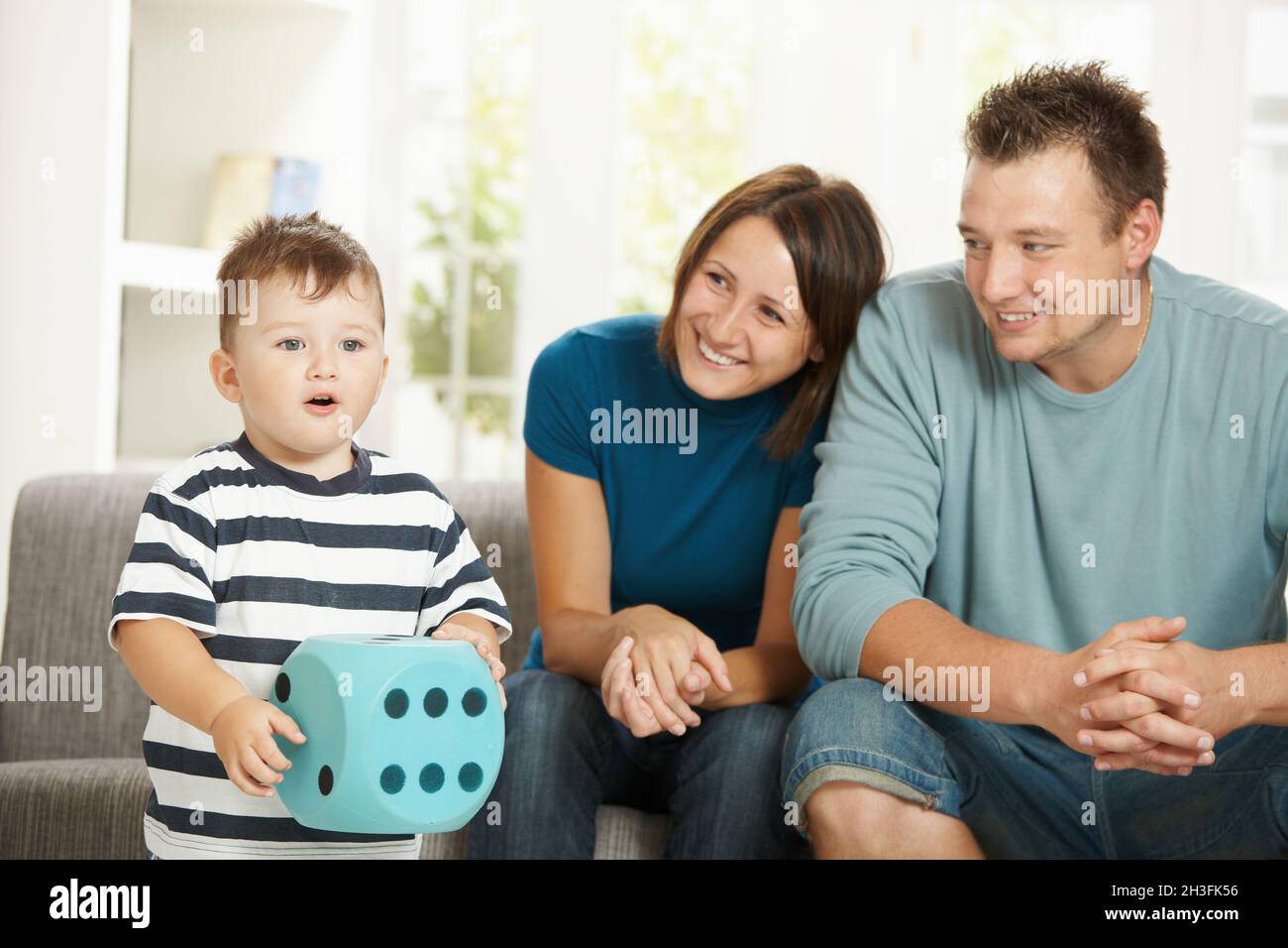 Little boy playing with die Stock Photo - Alamy