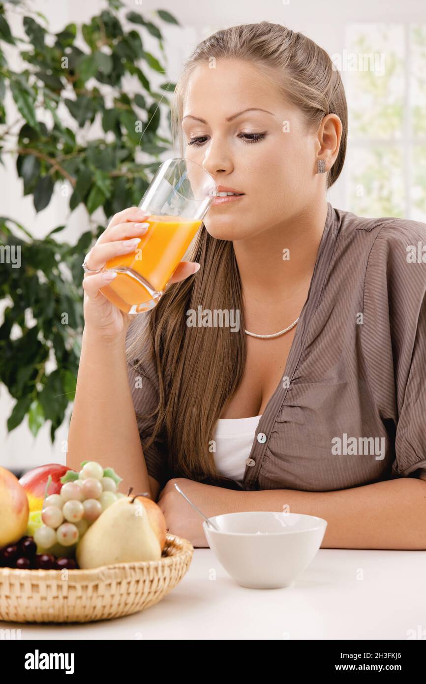 Young woman drinking orange juice Stock Photo - Alamy