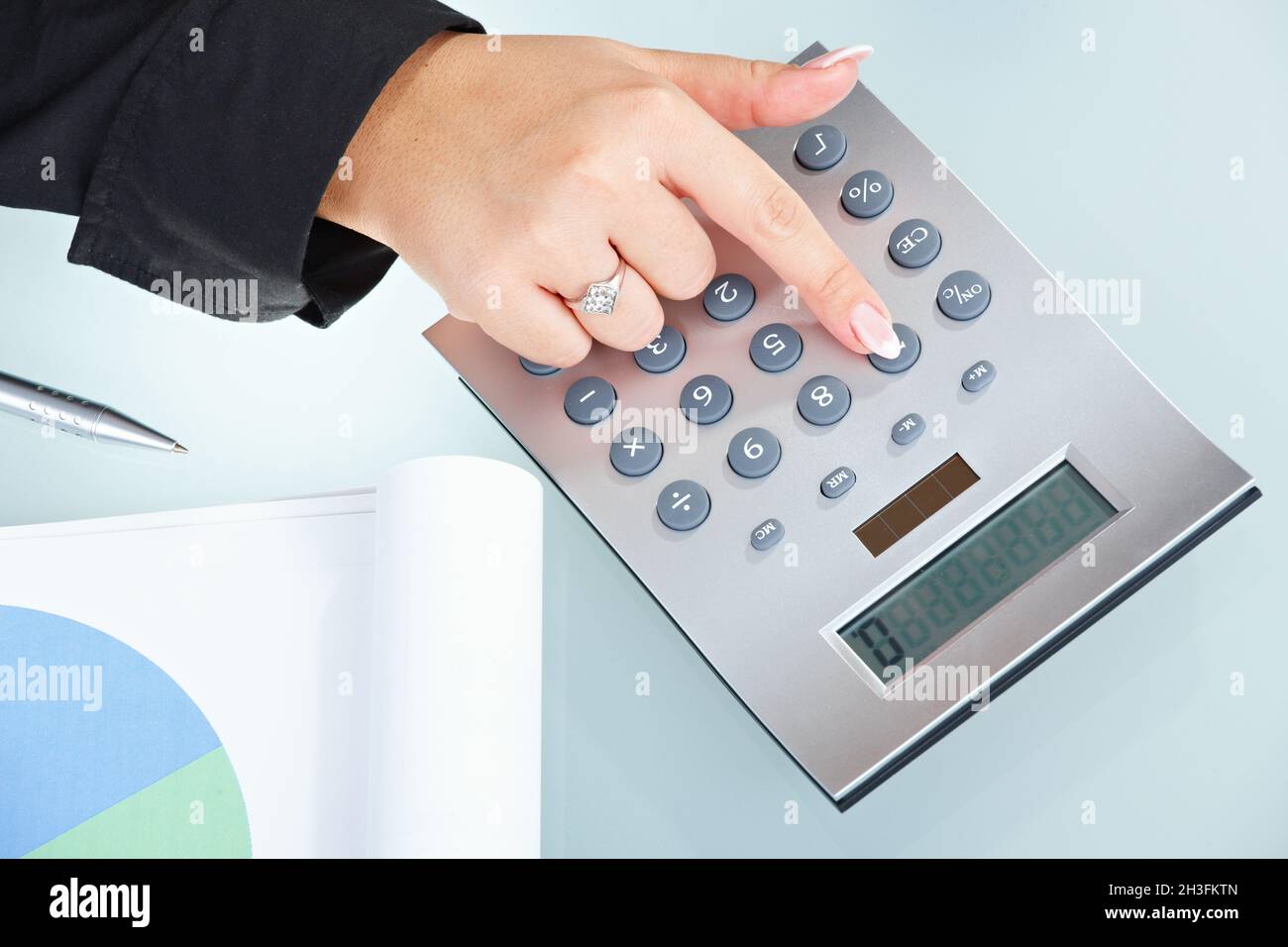 Female hand using calculator Stock Photo - Alamy