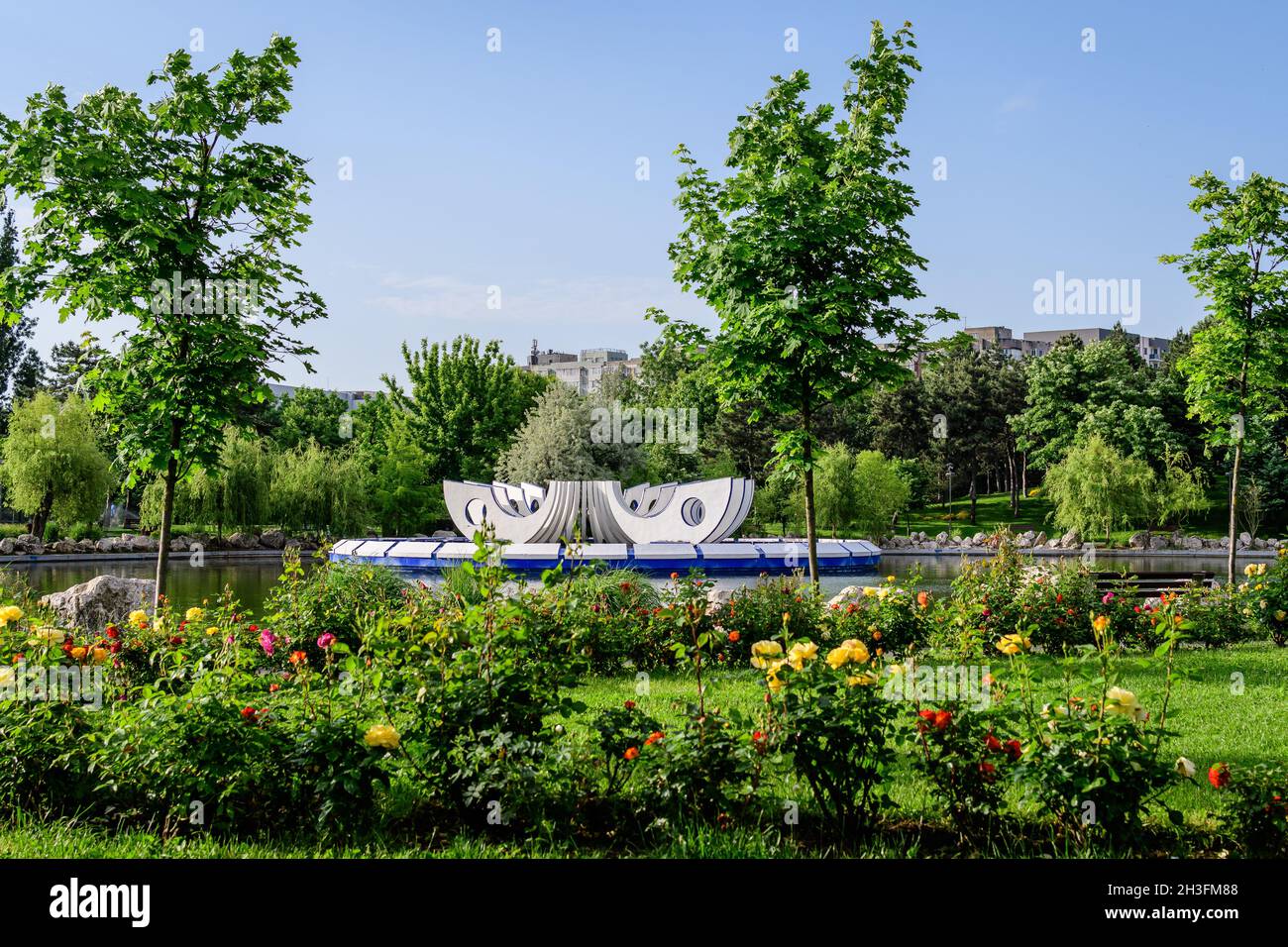 Landscape with the lake, decorative fountain and vivid green trees in ...