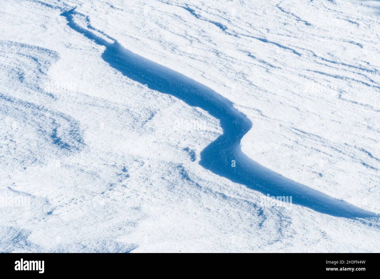 cut shapes in the snow from the strong winter wind on the ridge of the ...