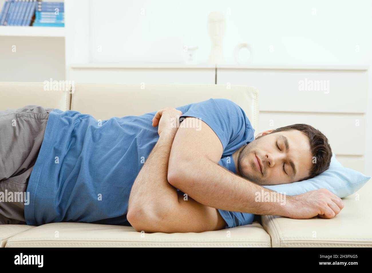 Man sleeping on couch Stock Photo - Alamy