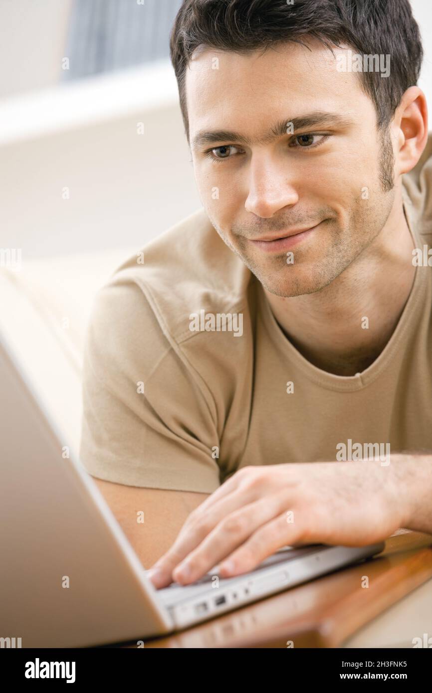 Man using laptop computer at home Stock Photo - Alamy