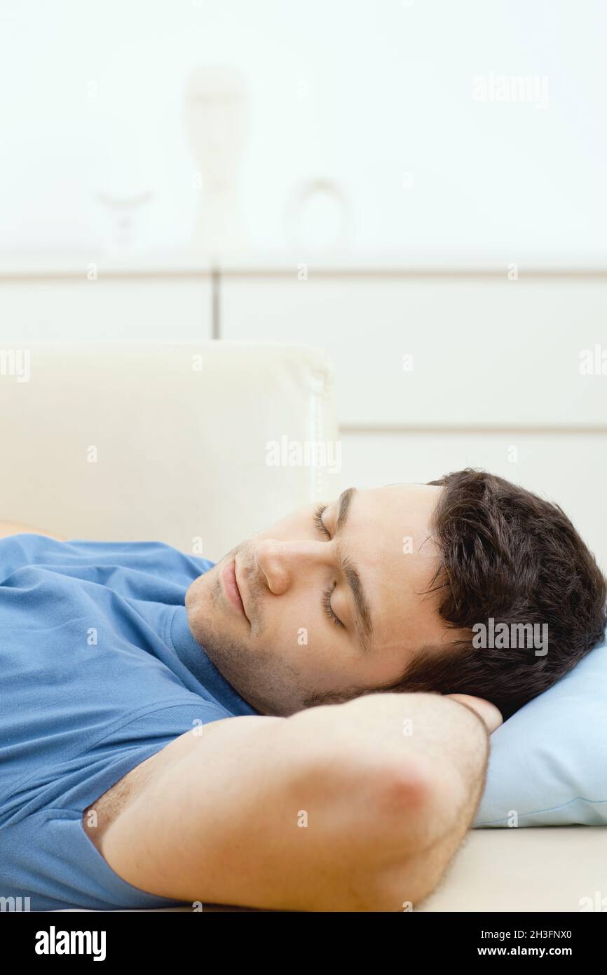 Man sleeping on couch Stock Photo - Alamy