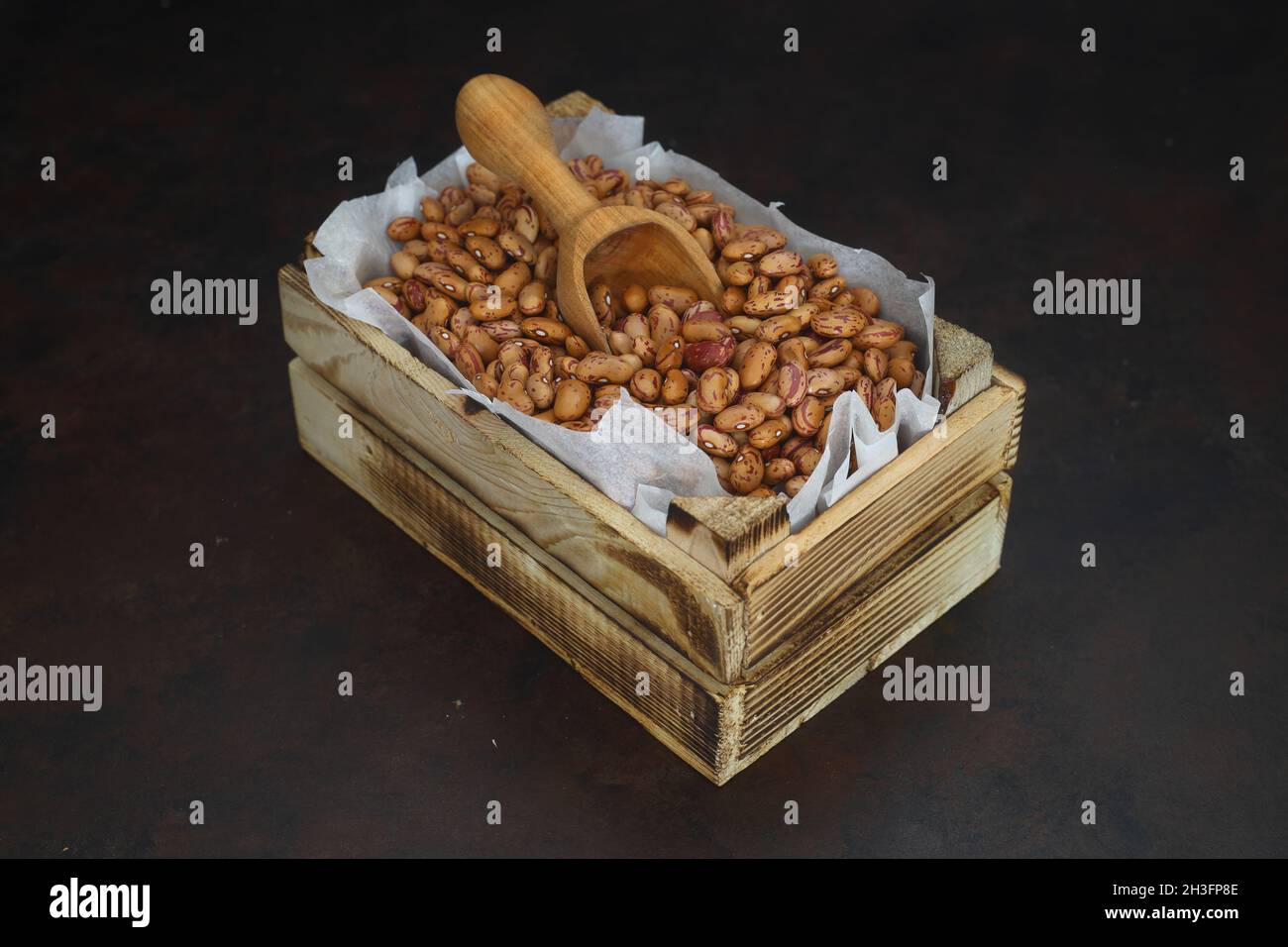 Kidney beans in a small wooden crate, isolated on black background ...