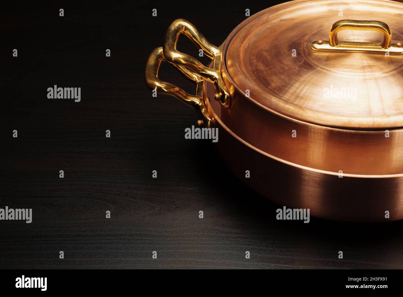 Shiny vintage copper cookware over dark background Stock Photo - Alamy