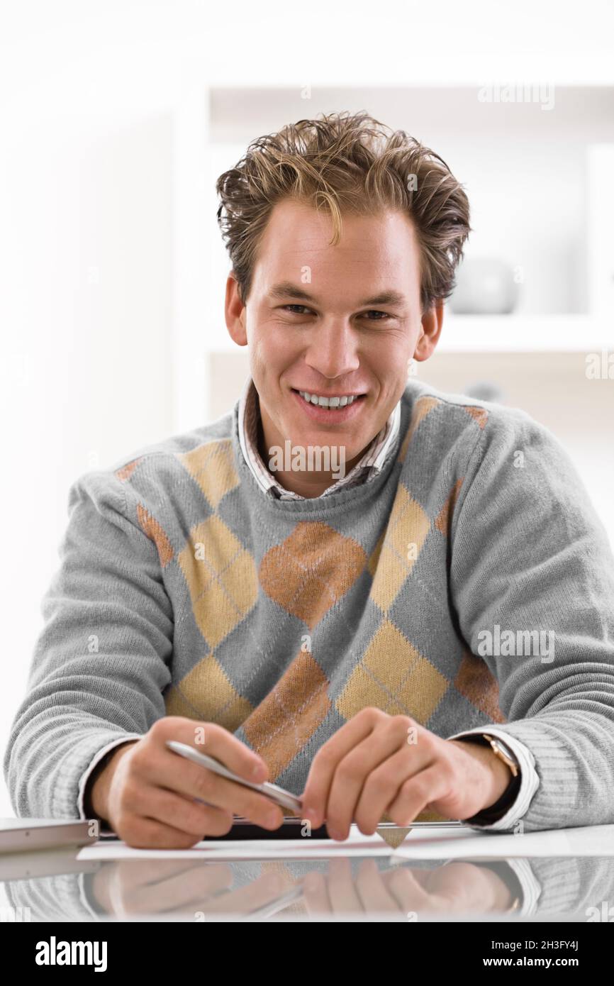Young man writing at desk Stock Photo - Alamy