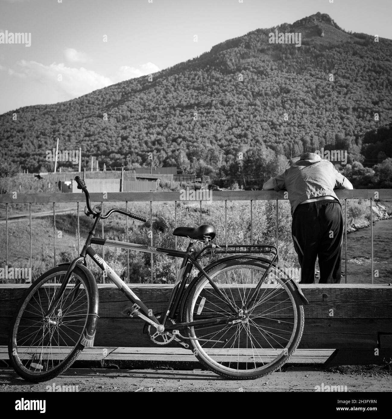 31st of July, Russia, Altay, man looks to the river from the bridge on ...