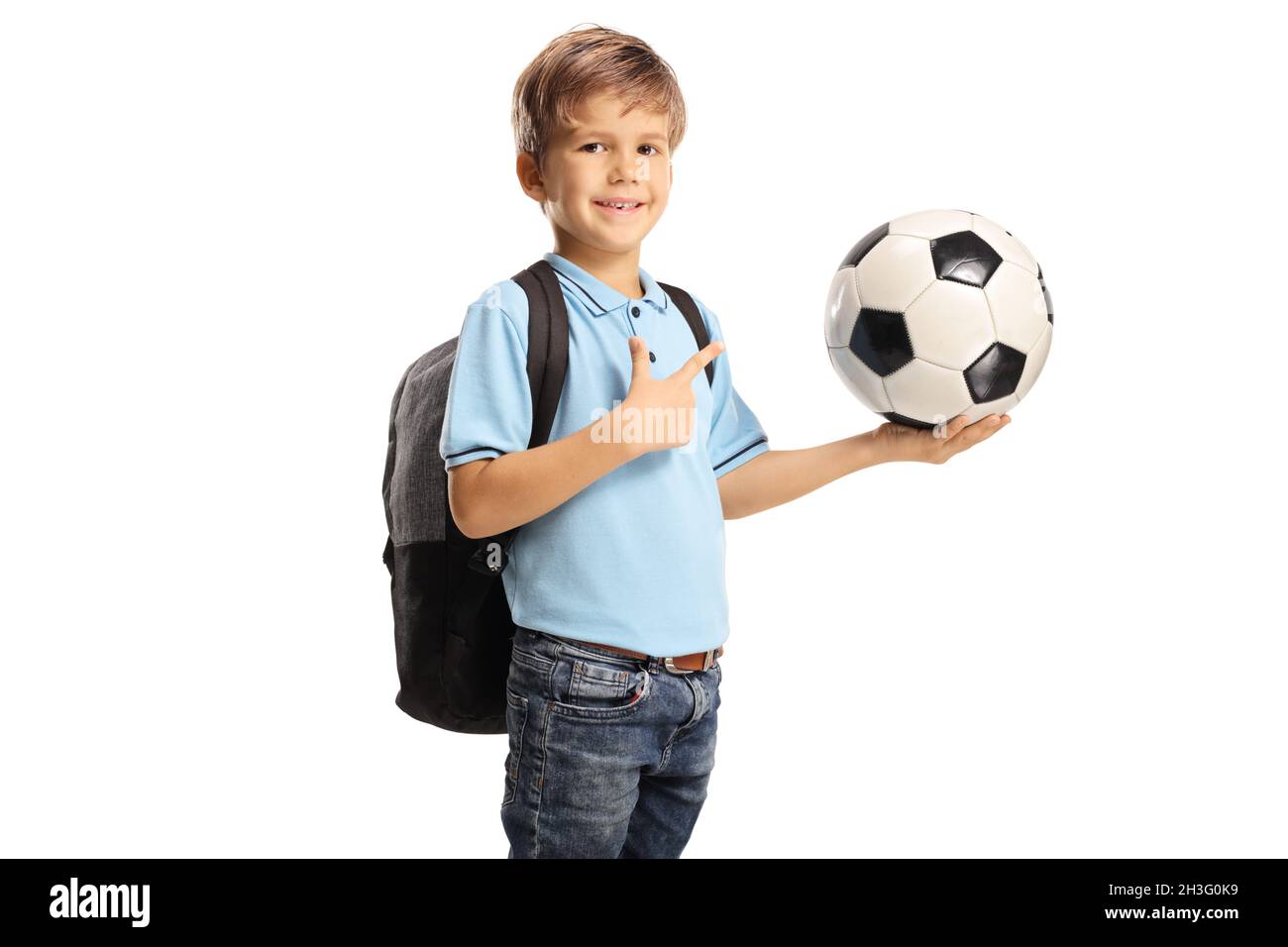 Boy with a backpack holding a football and pointing isolated on white ...