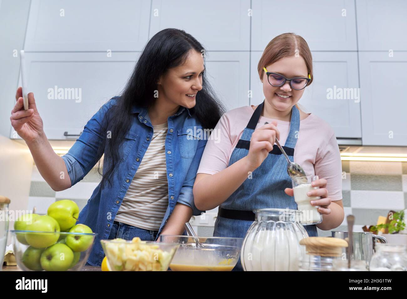 Mom and teenage daughter preparing apple pie together Stock Photo - Alamy