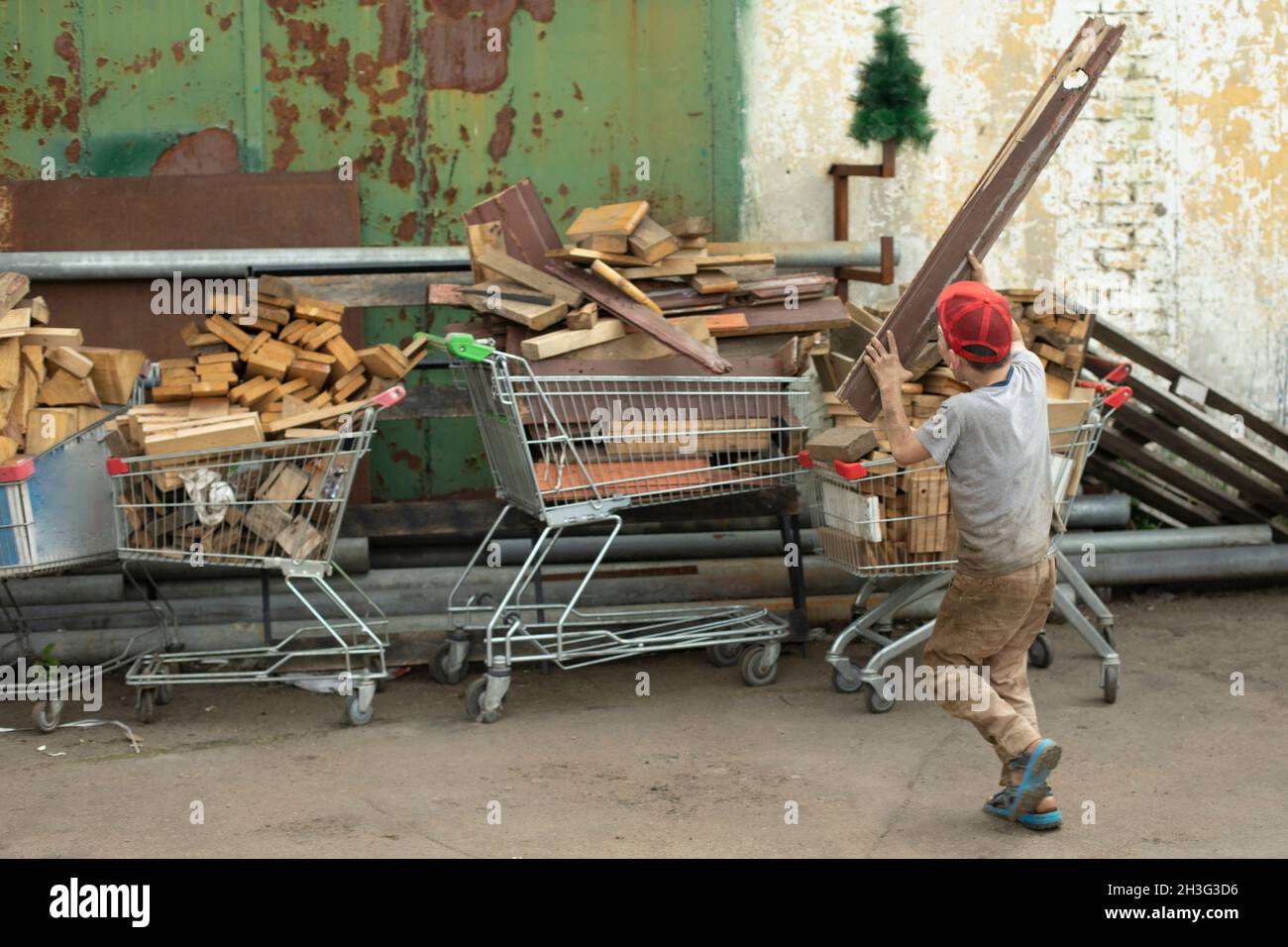 Child on the background of trolleys with construction debris. A boy in ...